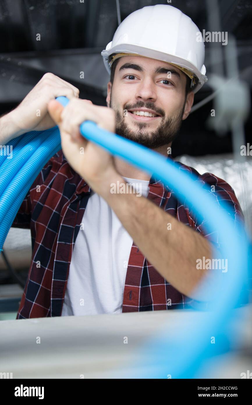 man installing a blue pvc water pipe Stock Photo - Alamy
