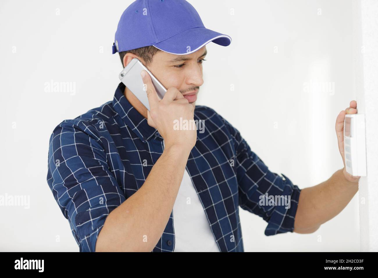 a man is installing an electrical device on a wall Stock Photo - Alamy