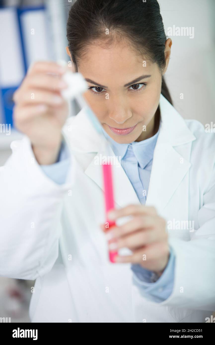 female scientist dripping liquid into test tube Stock Photo - Alamy