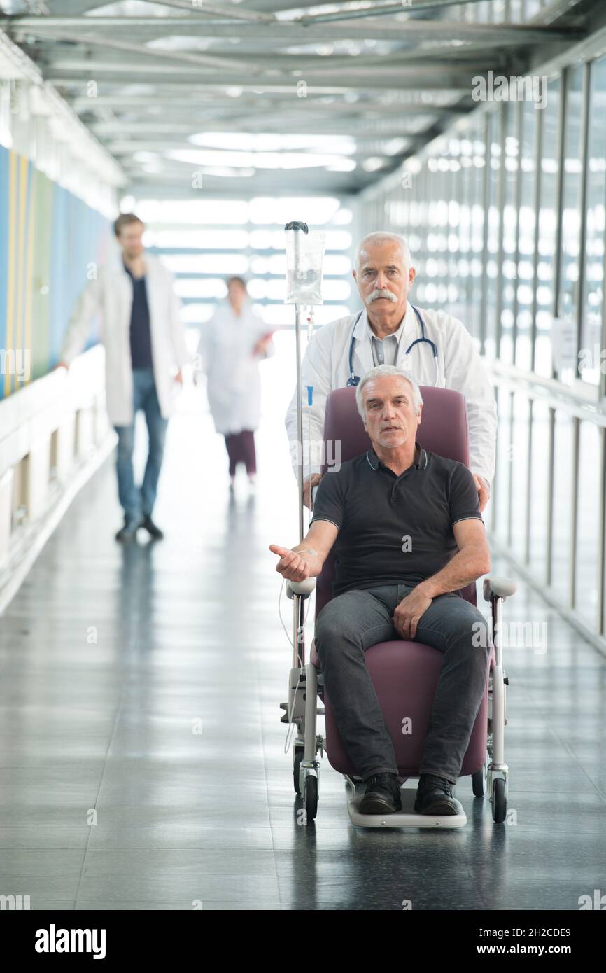 doctor pushing senior male patient in wheelchair Stock Photo - Alamy