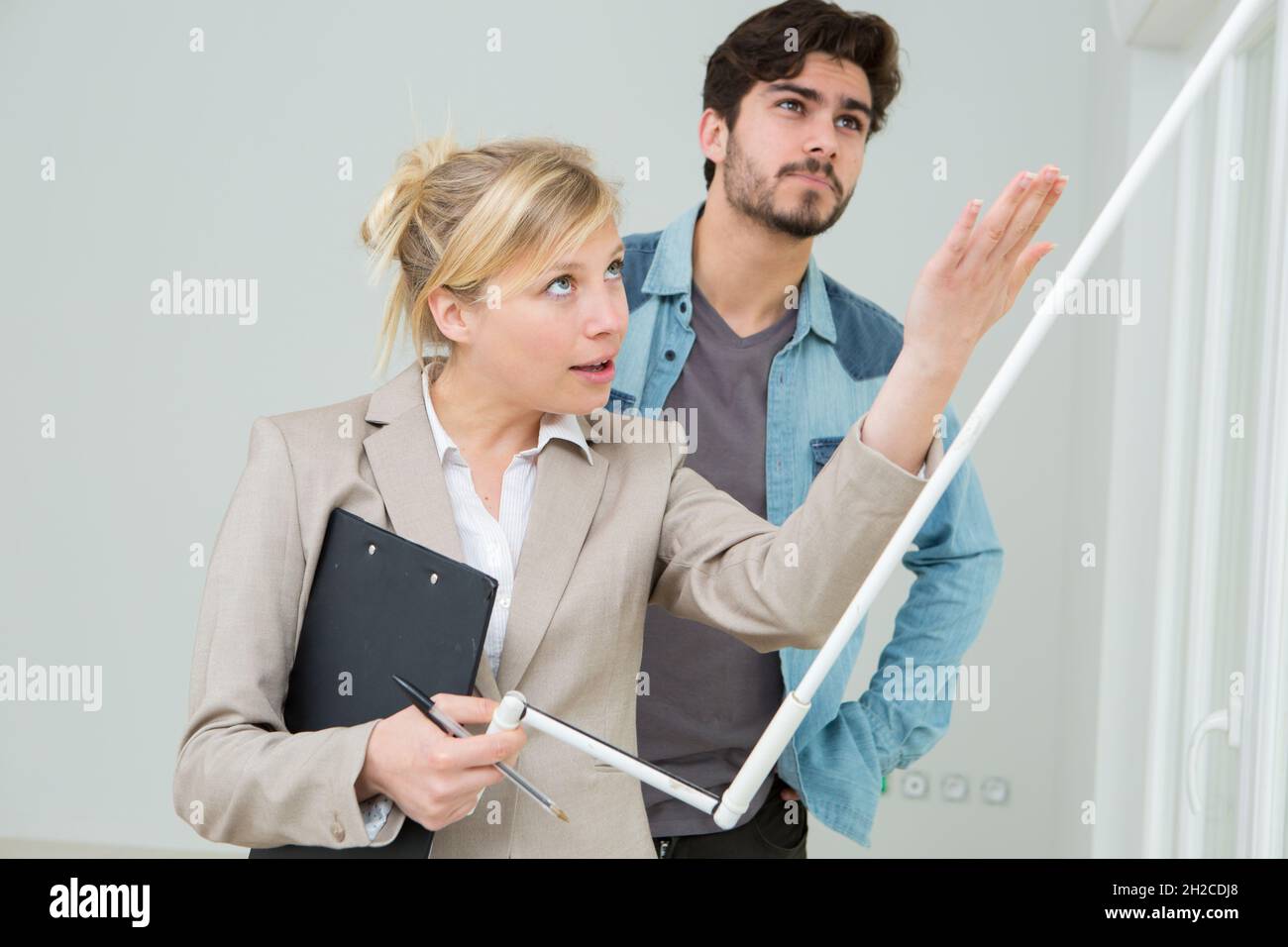 agent showing window blinds to client visiting property Stock Photo - Alamy