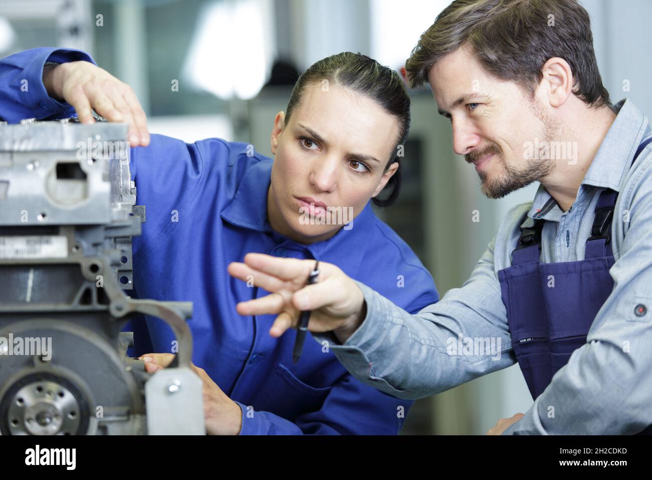 two mechanics repairing or inspecting an engine Stock Photo - Alamy