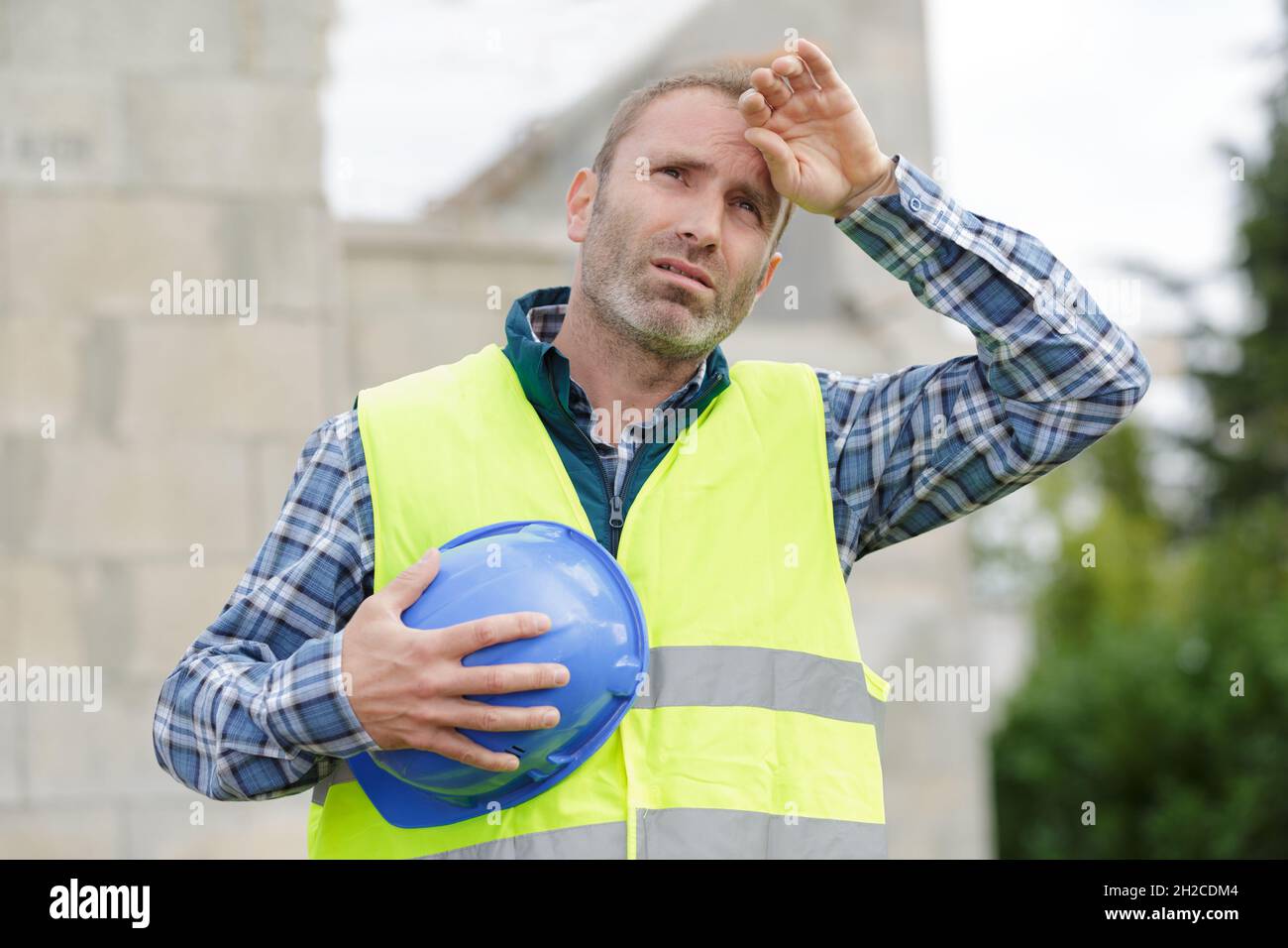 builder man with tired face wipes forehead Stock Photo - Alamy