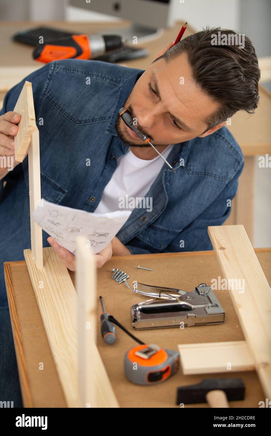 man putting together self assembly furniture in new home Stock Photo ...