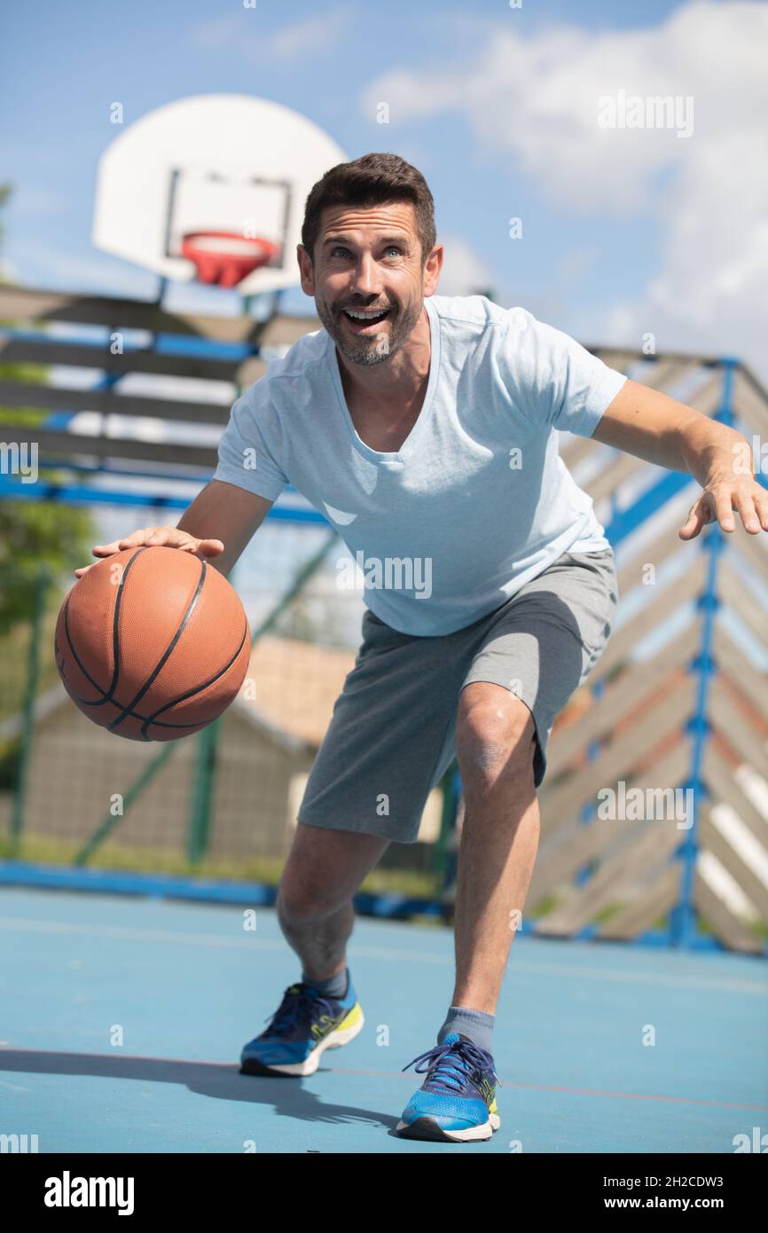 handsome smiling man carrying a basketball ball Stock Photo - Alamy