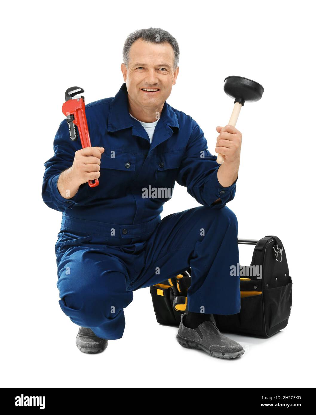 Mature plumber with pipe wrench and force cup on white background Stock ...