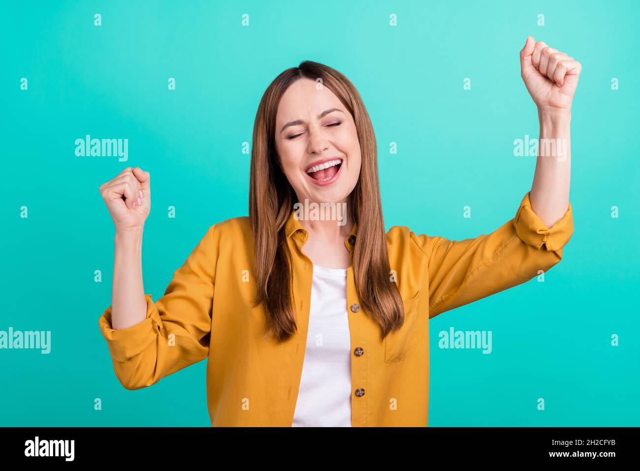 Photo of charming astonished mature lady wear yellow shirt rising fists ...