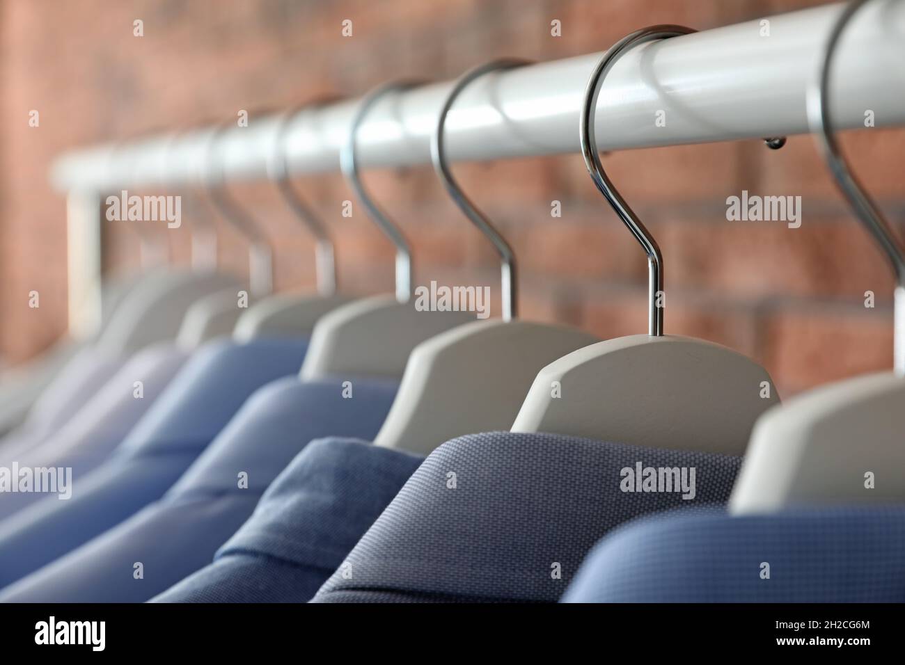 Wardrobe rack with men's clothes on hangers, closeup Stock Photo - Alamy