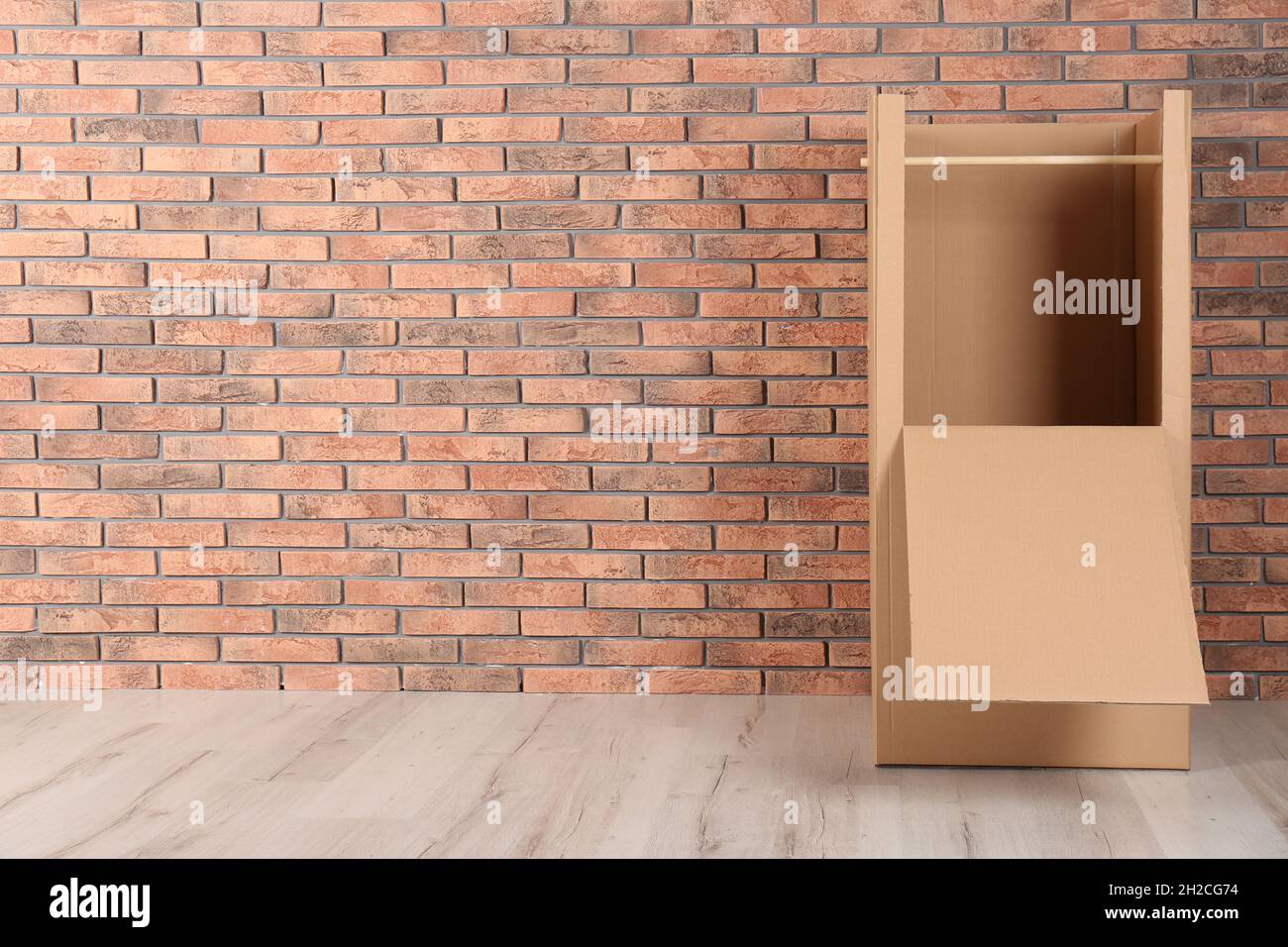 Empty wardrobe box against brick wall indoors. Space for text Stock ...
