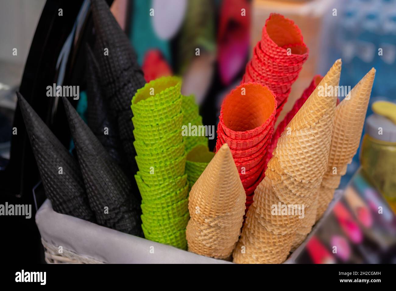 Stacks of many colorful empty waffle cones at outdoor food market ...