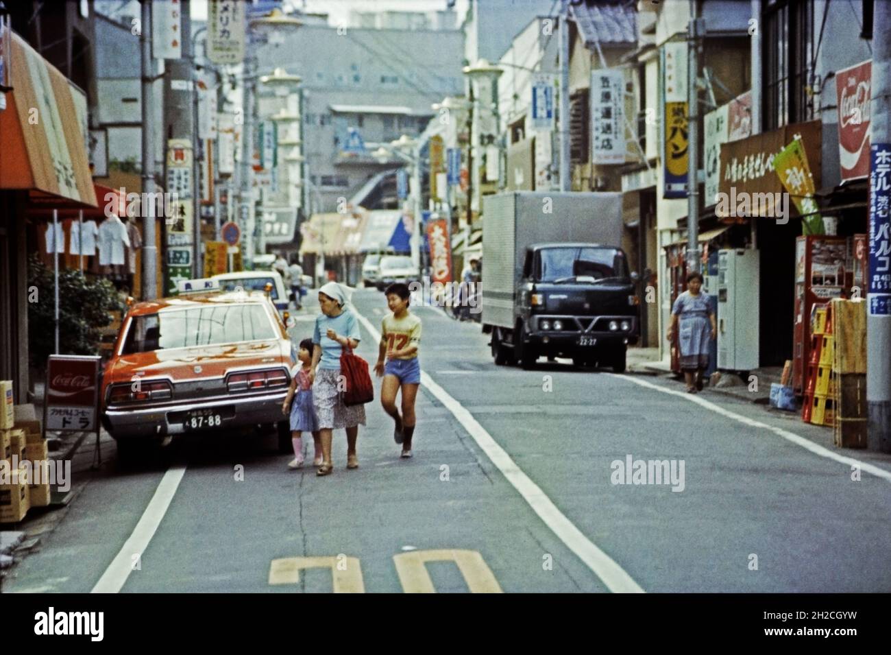 A woman with two children crosses the street. Tokio, Japan, 1970s Stock ...