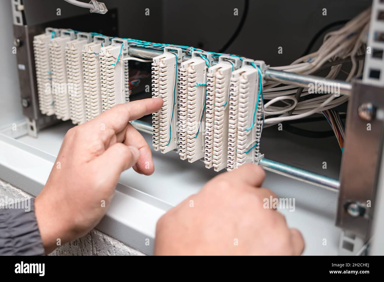 A man electrician checks the terminals of telephone communication ...