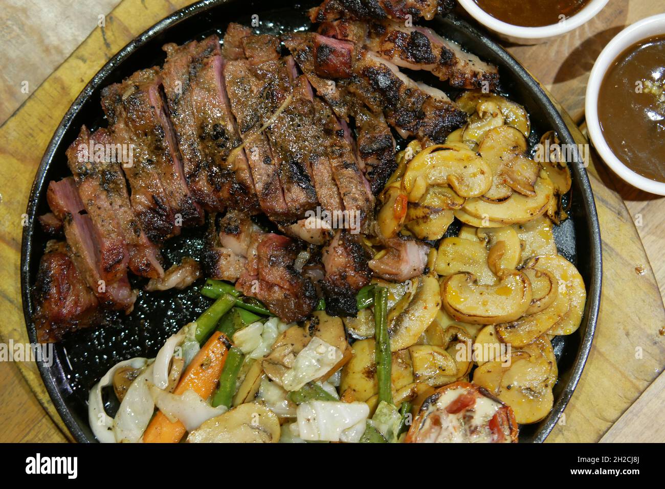 beef steaks meat with vegetables on a plate Stock Photo - Alamy