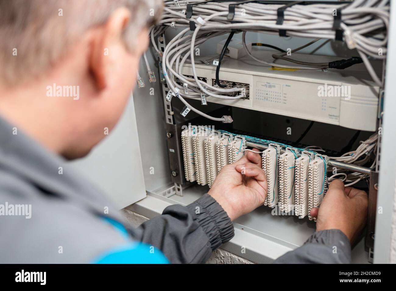 A man electrician checks the terminals of telephone communication ...