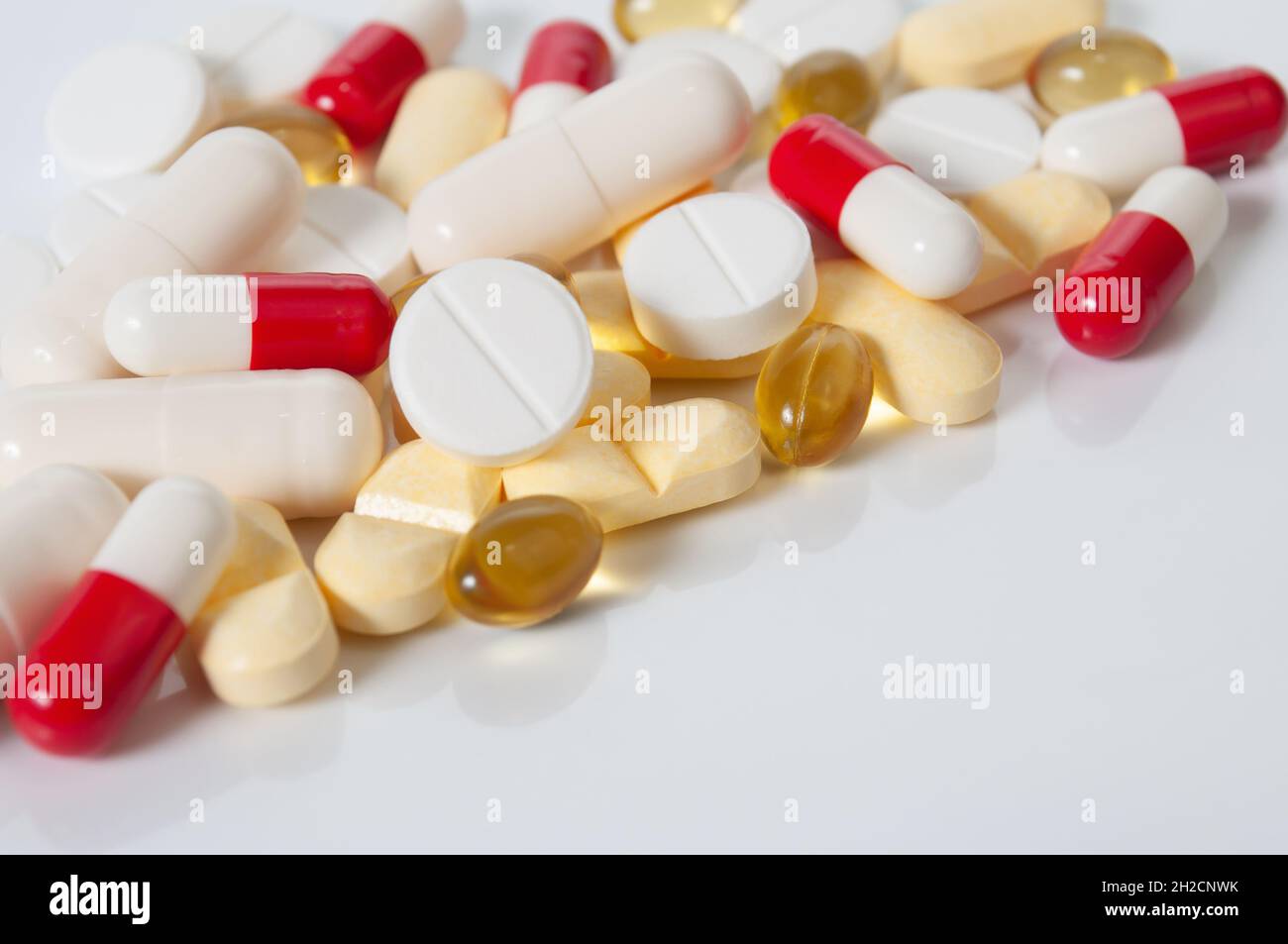Different pills, tablets and capsules on white background ...