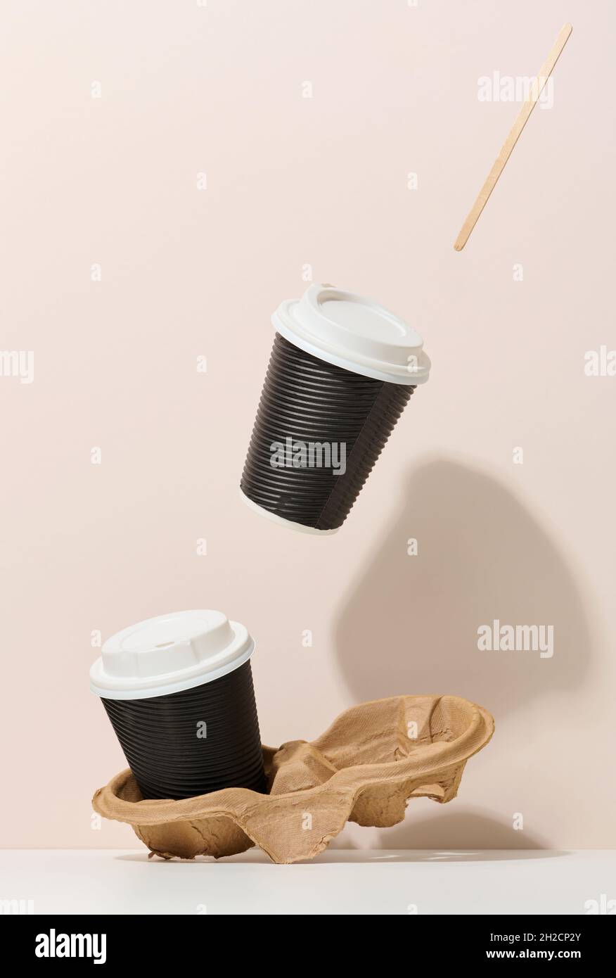 two brown cardboard cups with a white plastic lid. Disposable tableware ...