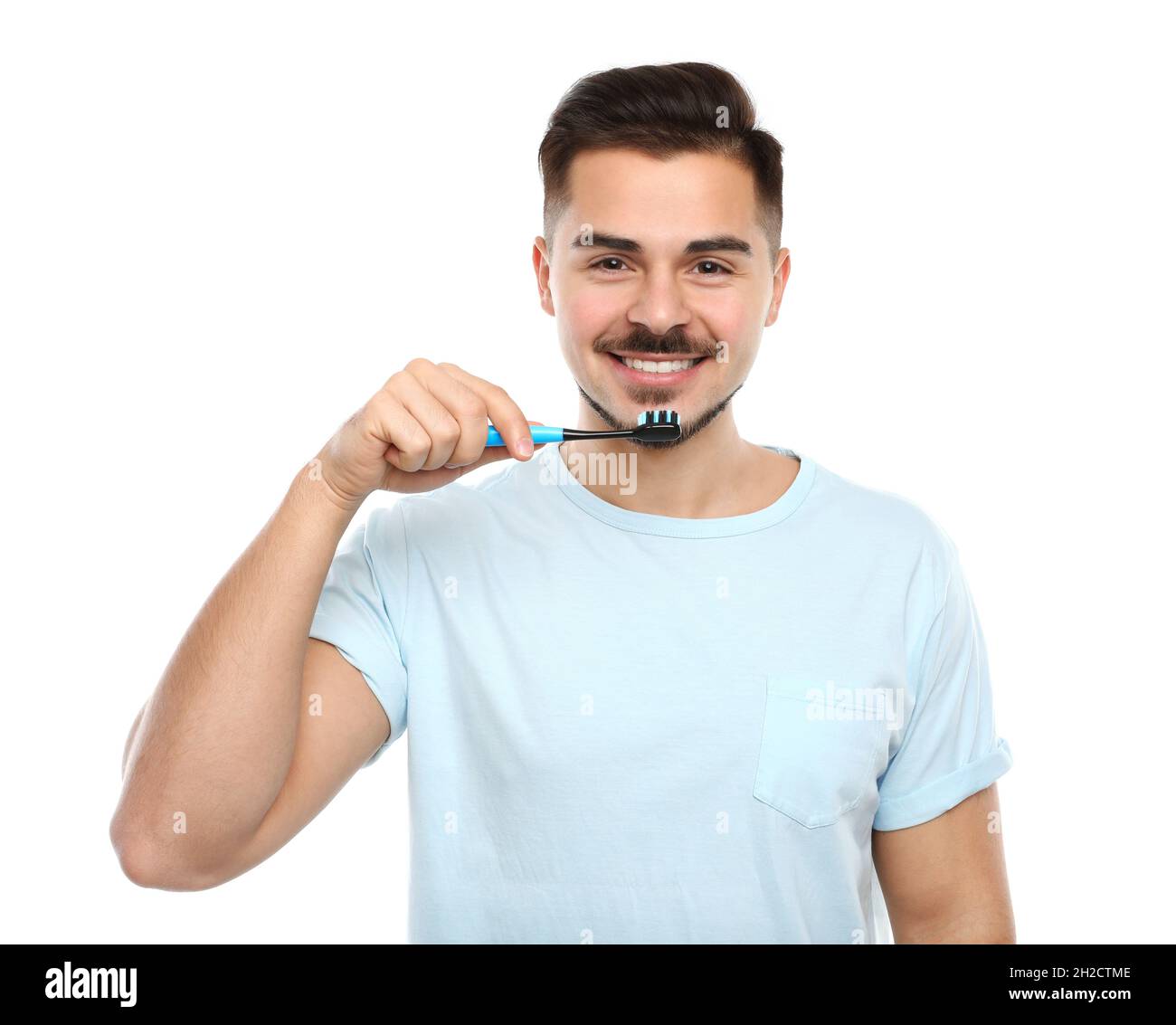 Young man brushing teeth on white background Stock Photo - Alamy