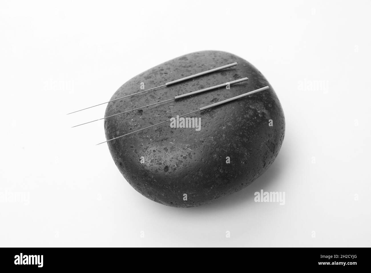 Acupuncture needles and stone on white background Stock Photo - Alamy
