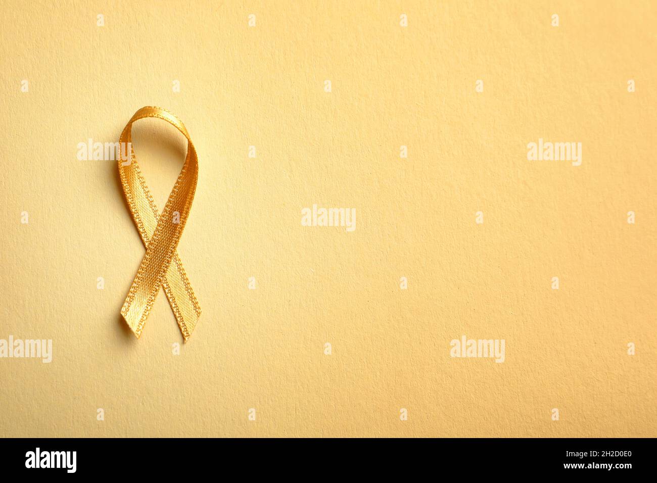Gold ribbon on color background, top view. Cancer awareness Stock Photo ...