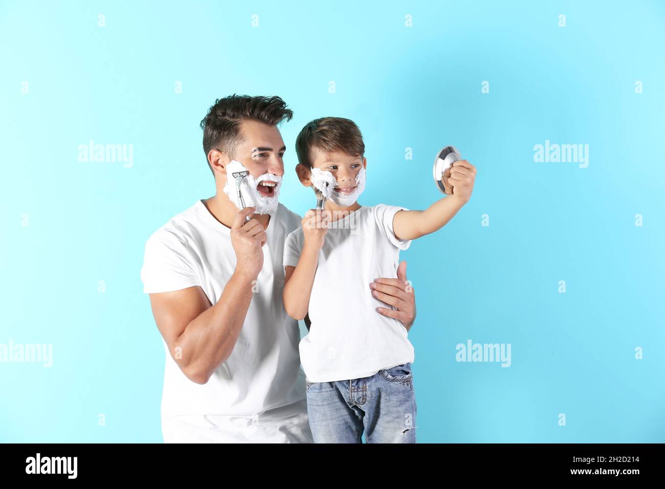 Father and son shaving on color background Stock Photo - Alamy