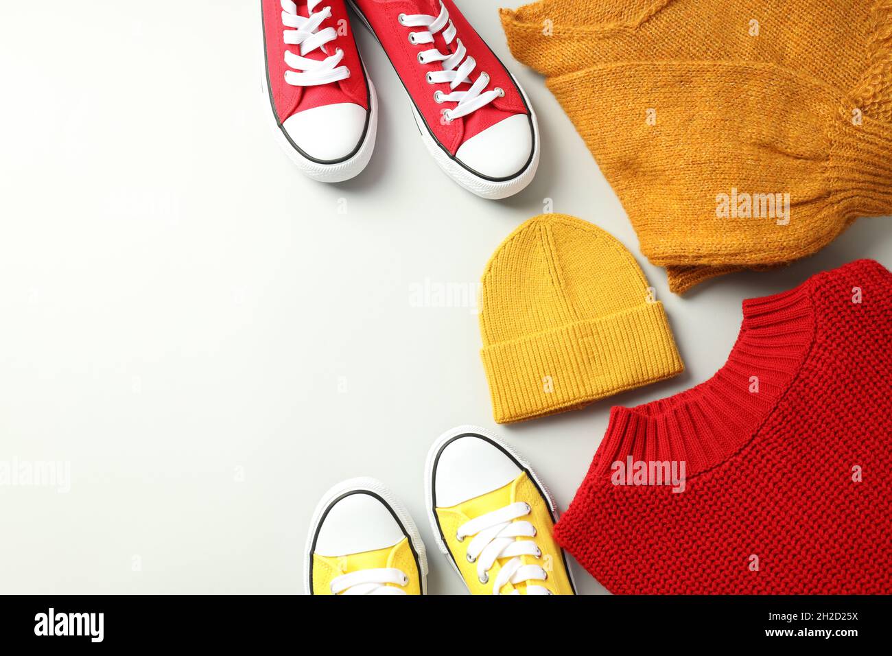 Sweaters, sneakers and knitted hat on white background Stock Photo - Alamy