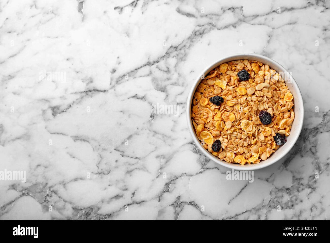 Bowl of whole grain cereal on marble table, top view with space for ...