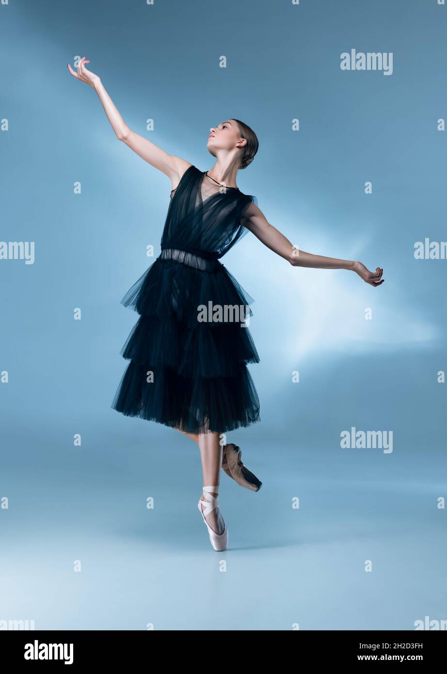 Young and graceful ballet dancer in black stage outfit, dress isolated ...