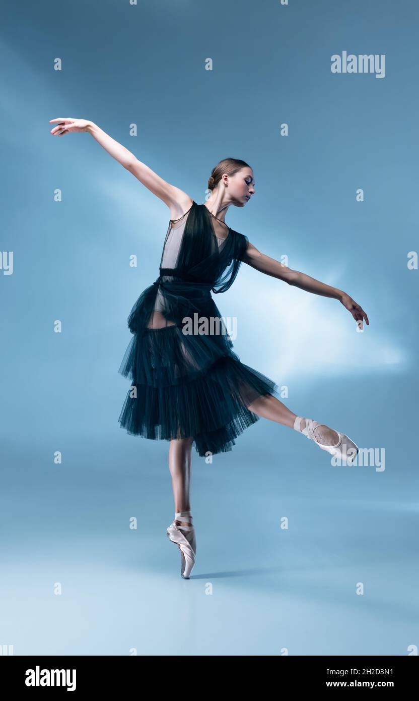 Young and graceful ballet dancer in black stage outfit, dress isolated ...