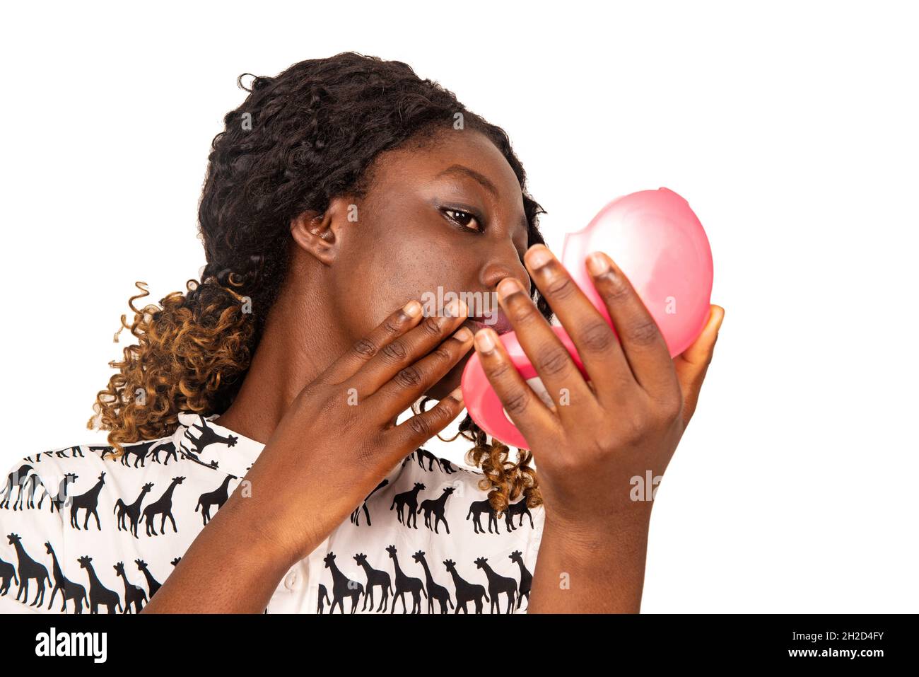 charming woman standing on white background staring at her face in a ...