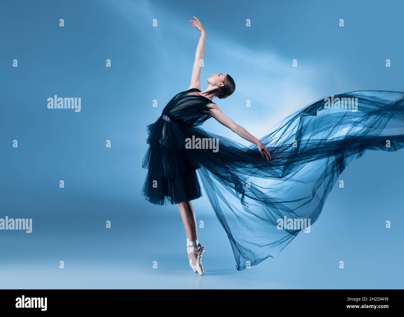 Young and graceful ballet dancer in black stage outfit, dress isolated ...