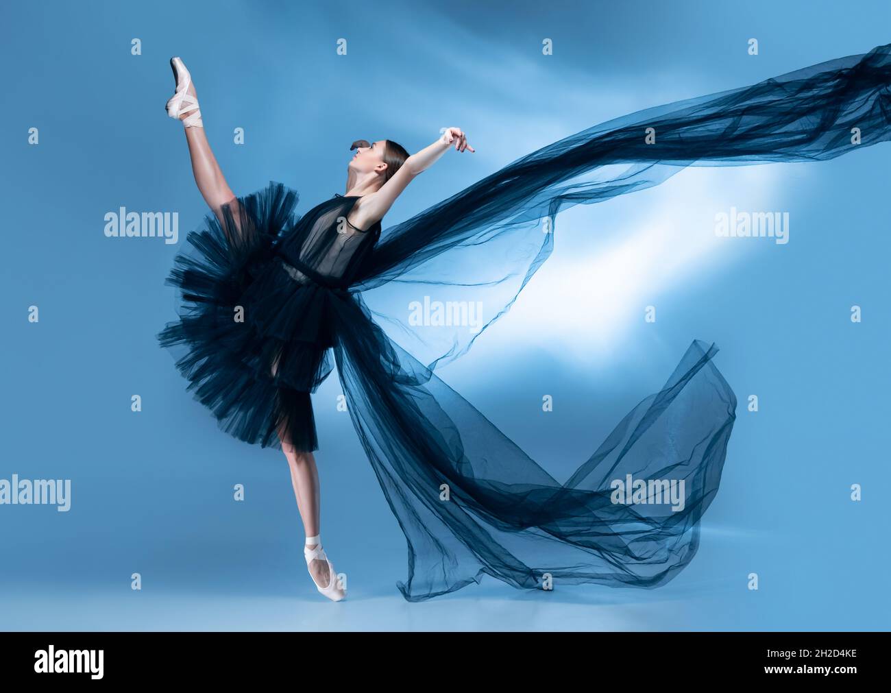 Young and graceful ballet dancer in black stage outfit, dress isolated ...