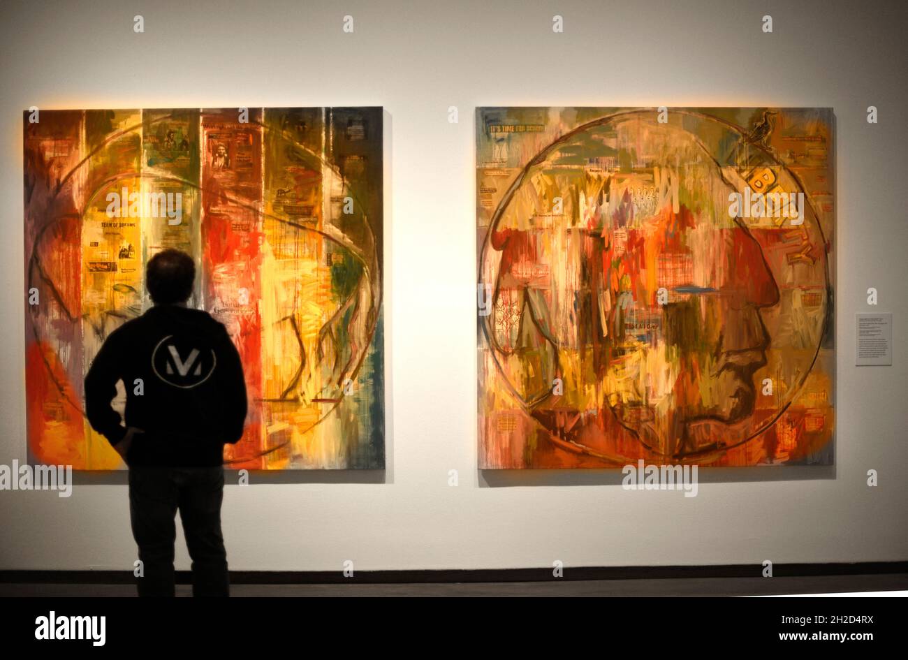 A museum visitor admires paintings by Native American artist and ...