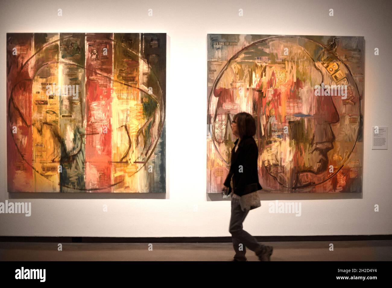 A museum visitor admires paintings by Native American artist and ...