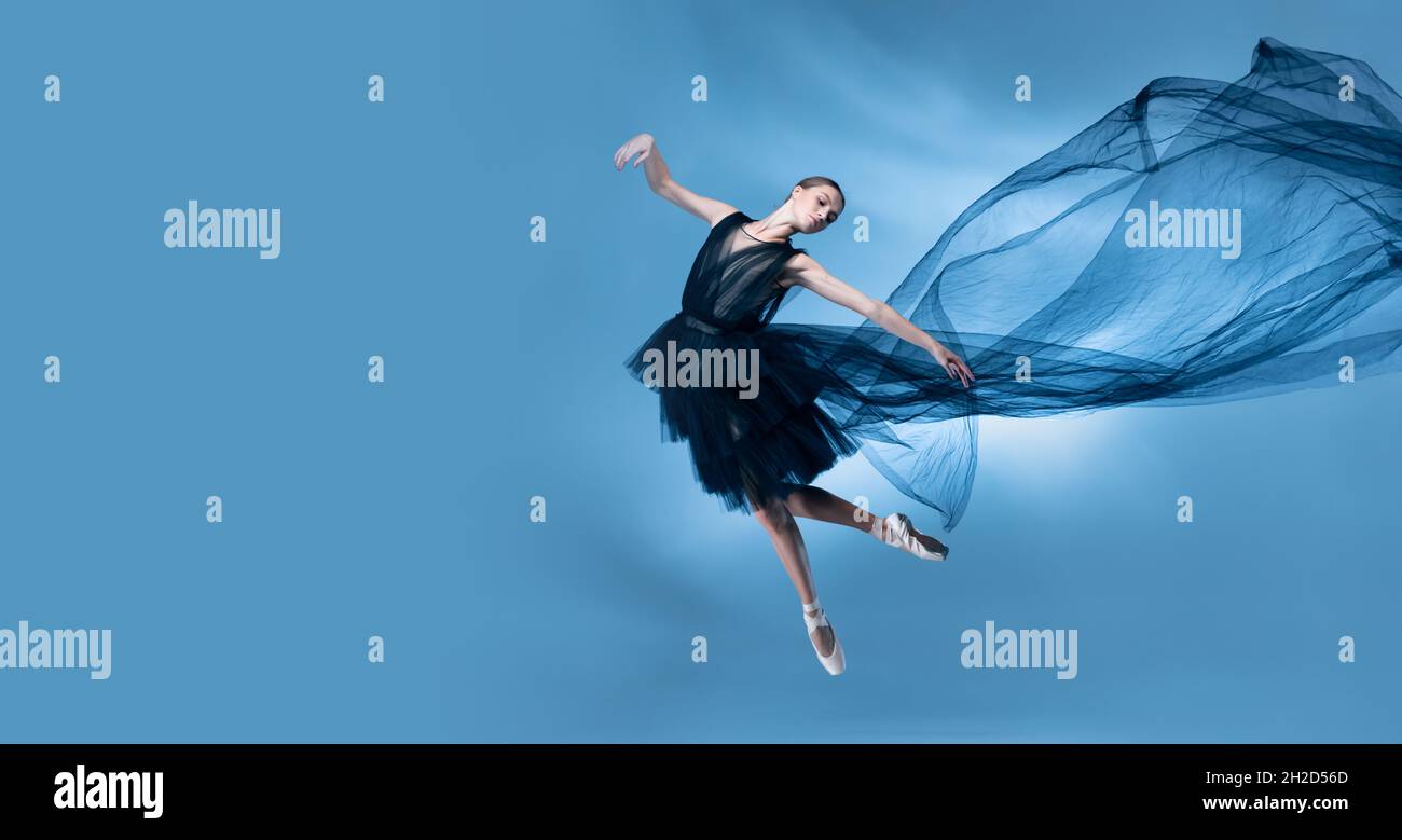 Young and graceful ballet dancer in black stage outfit, dress isolated ...