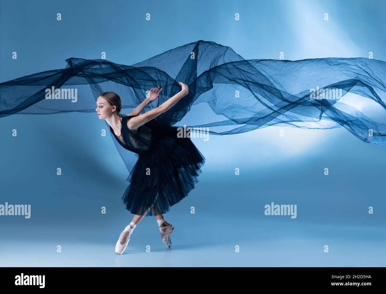 Young and graceful ballet dancer in black stage outfit, dress isolated ...