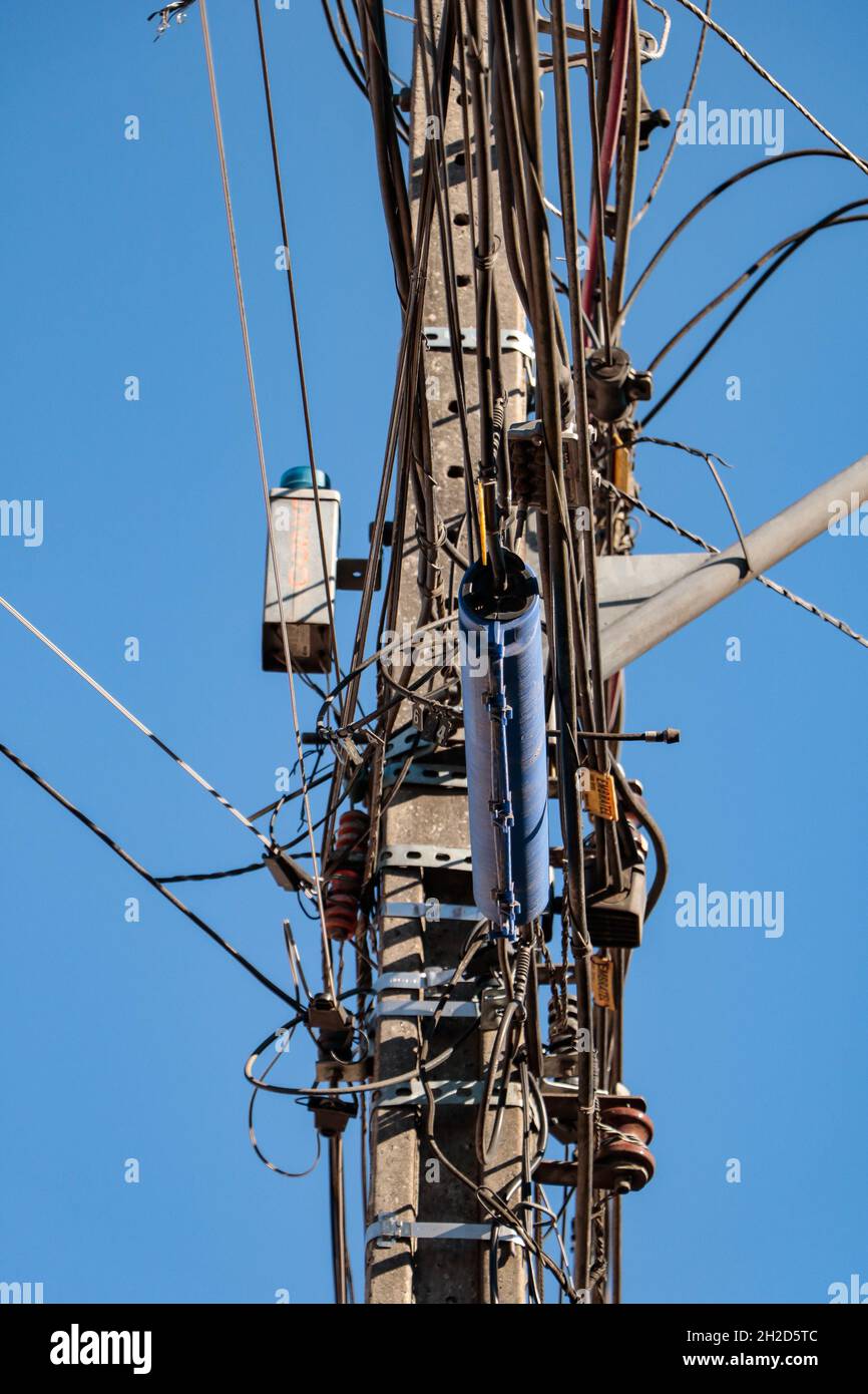 Public lighting electric network pole with a tangle of wires, with the ...