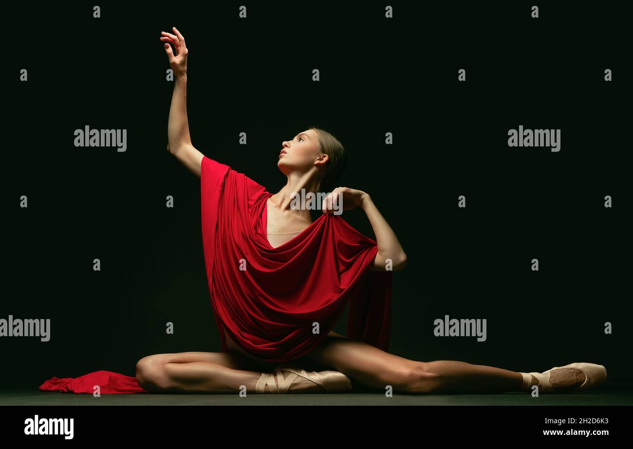 Graceful classic ballerina posing like greek goddess isolated on dark ...