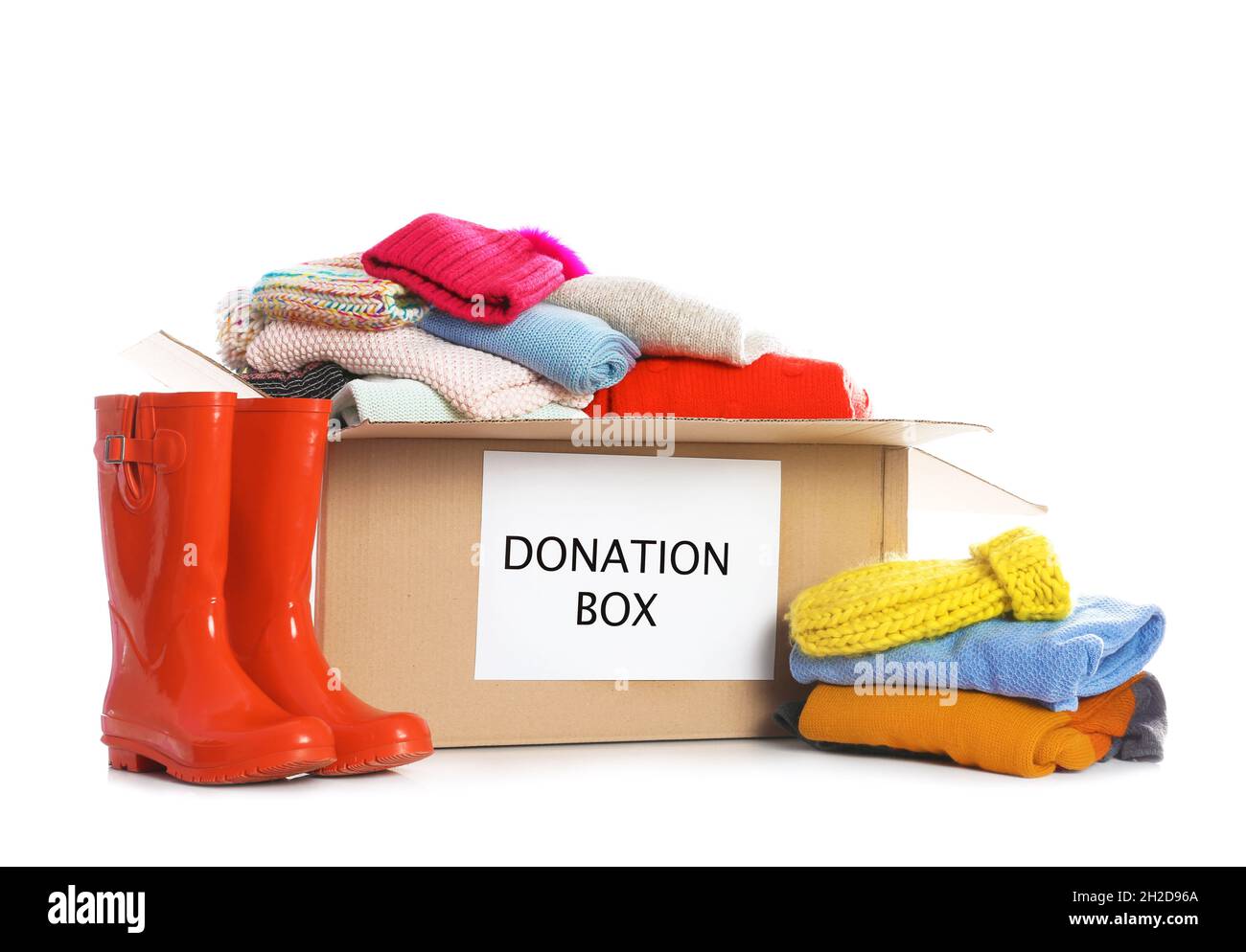 Donation box, rubber boots and clothes on white background Stock Photo ...