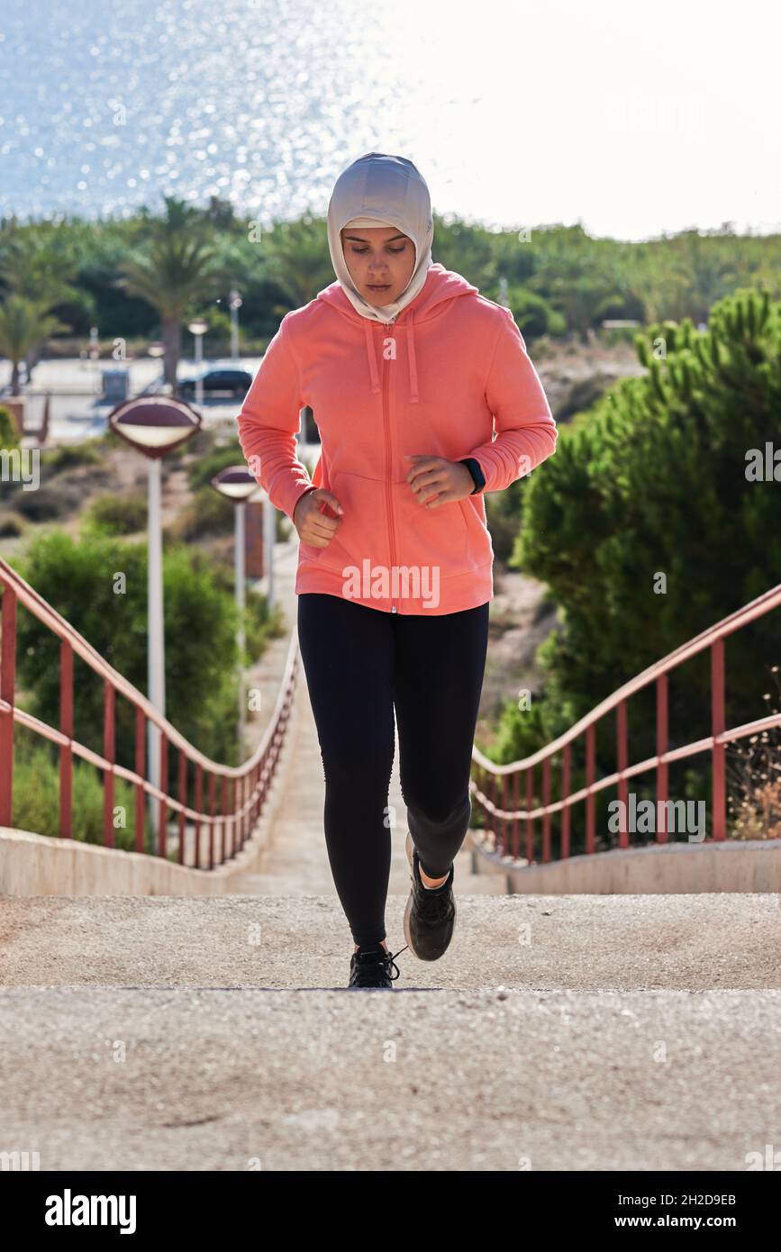 Muslim young woman wears a hijab while running Stock Photo - Alamy