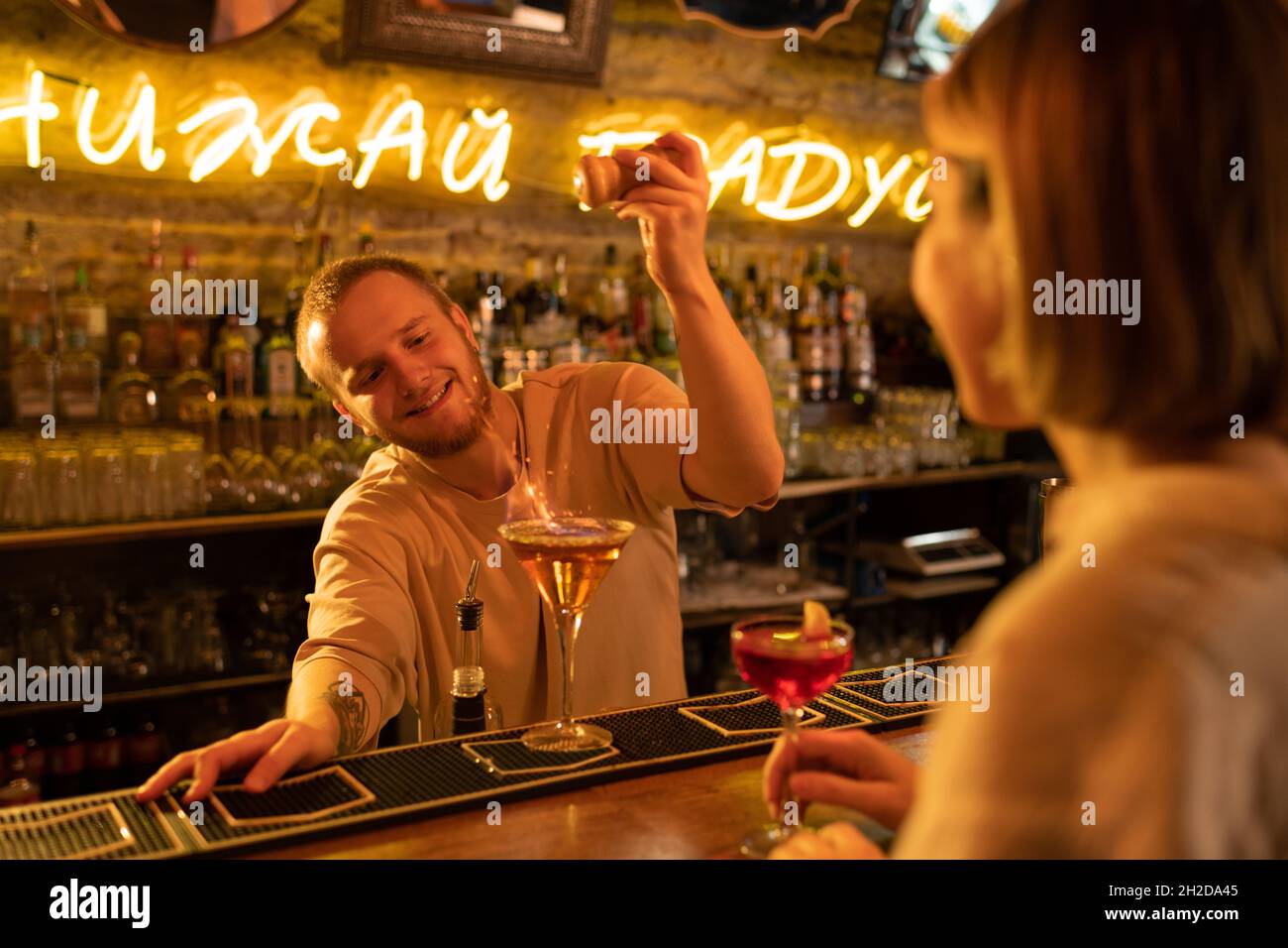 Bartender shaking ingredient over glass with burning cocktail for ...
