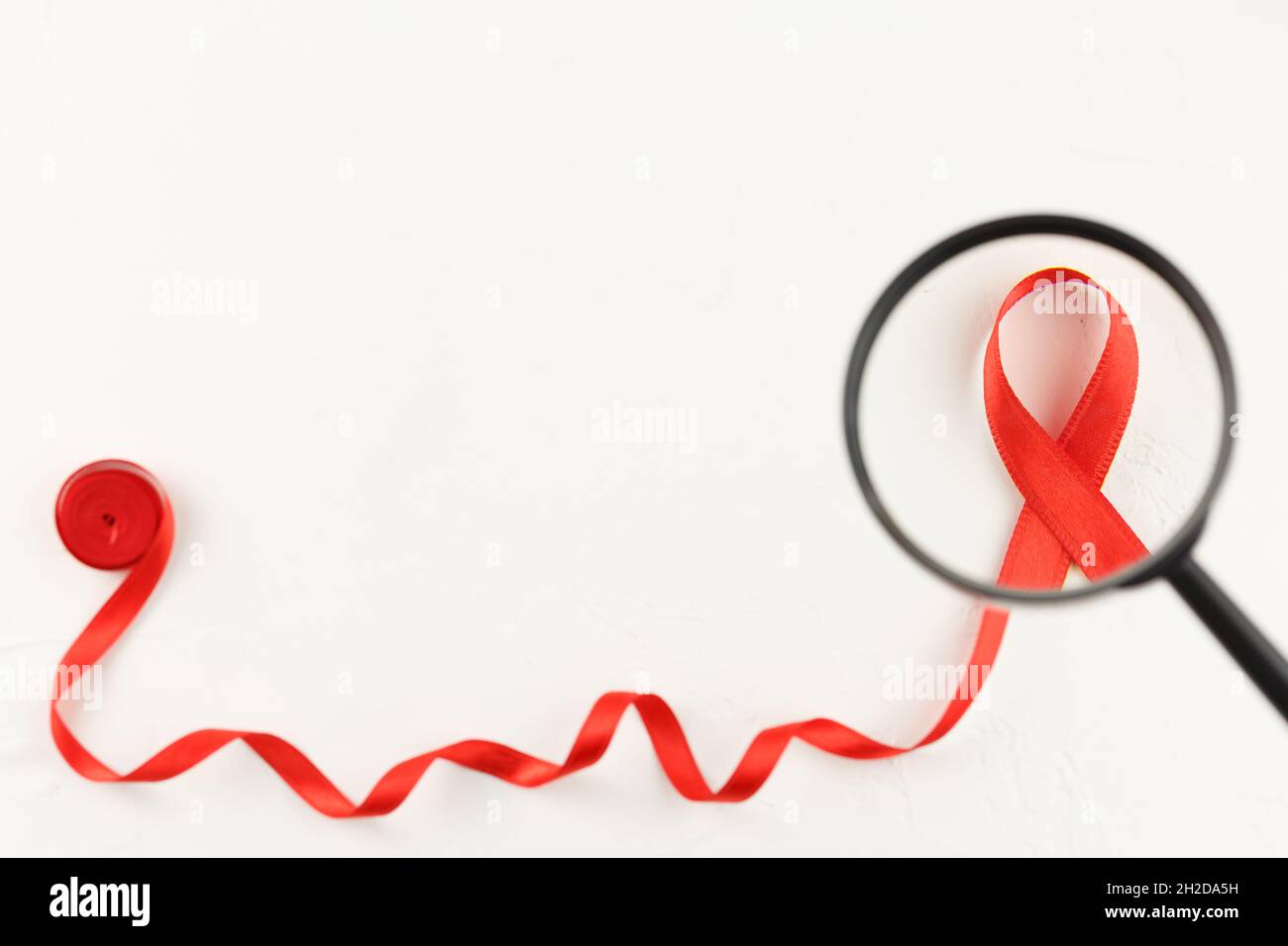 Cancer ribbon with magnifying glass Stock Photo - Alamy