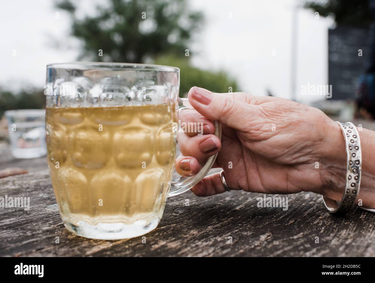 woman's hand holding a pint glass with cider in outside Stock Photo - Alamy