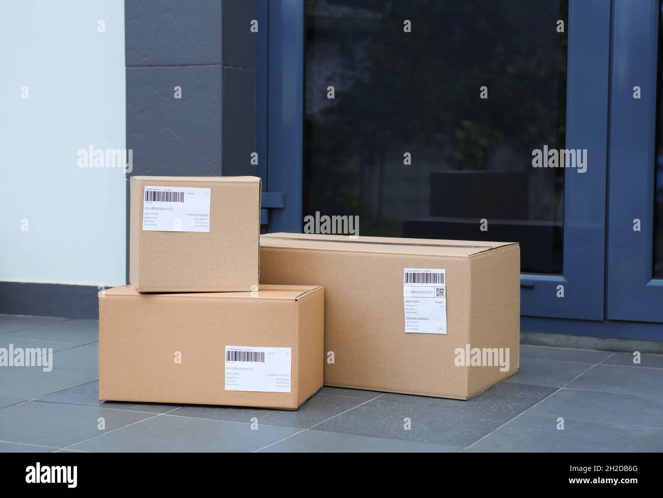 Parcel boxes on floor near office entrance Stock Photo - Alamy