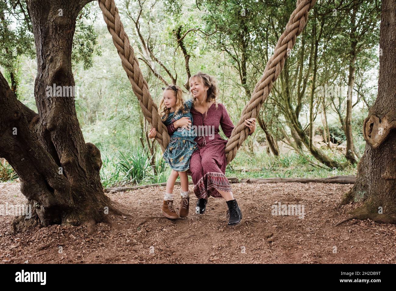 mother and daughter sat on an outdoor swing together happily Stock ...