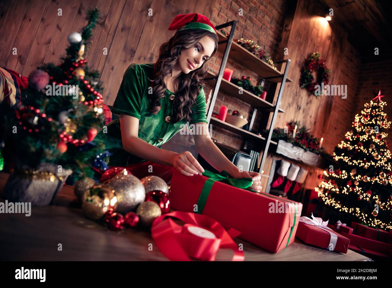 Portrait of attractive focused careful girl elf wrapping ugly pullover ...