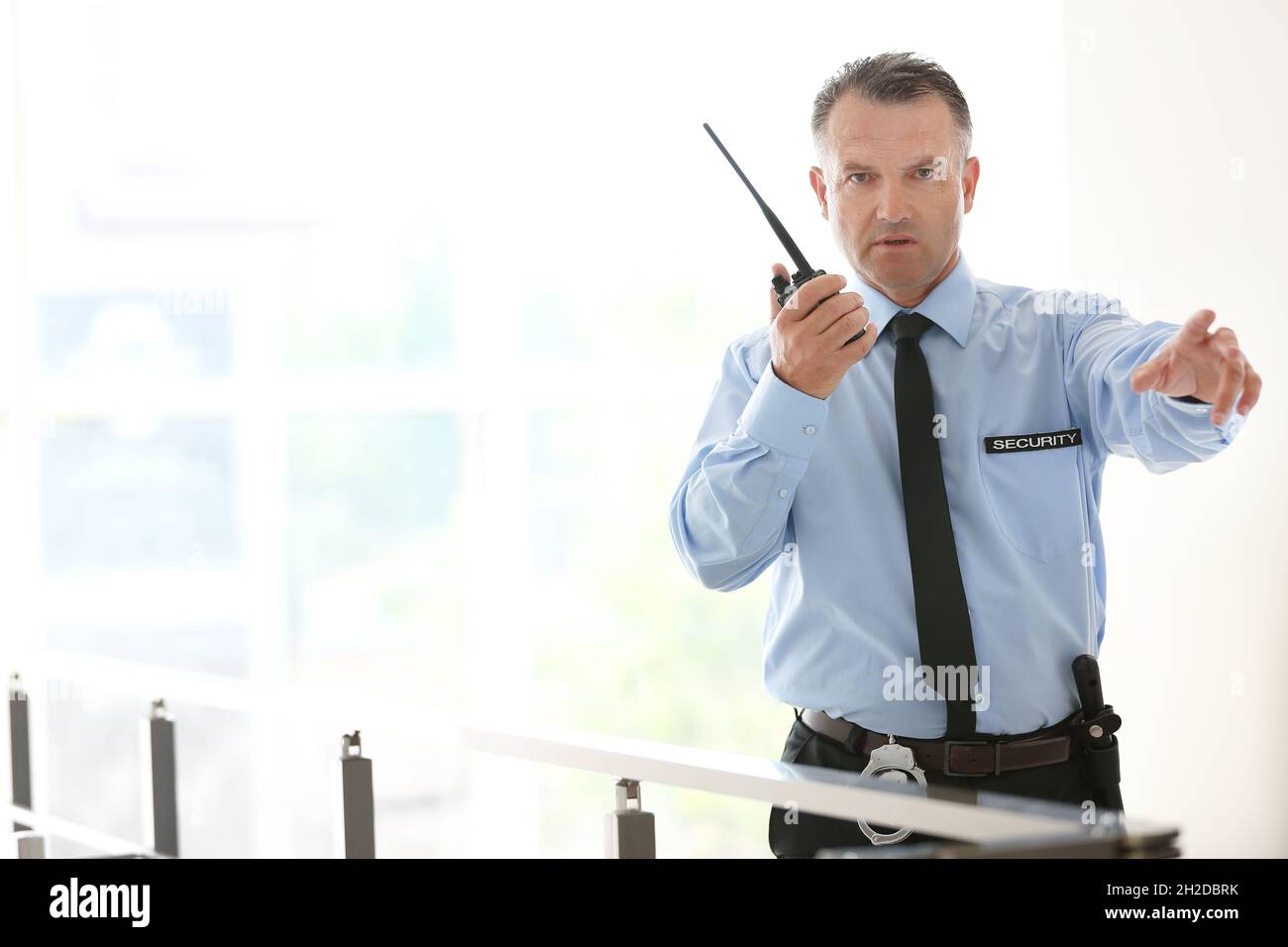 Male security guard using portable radio transmitter indoors Stock ...