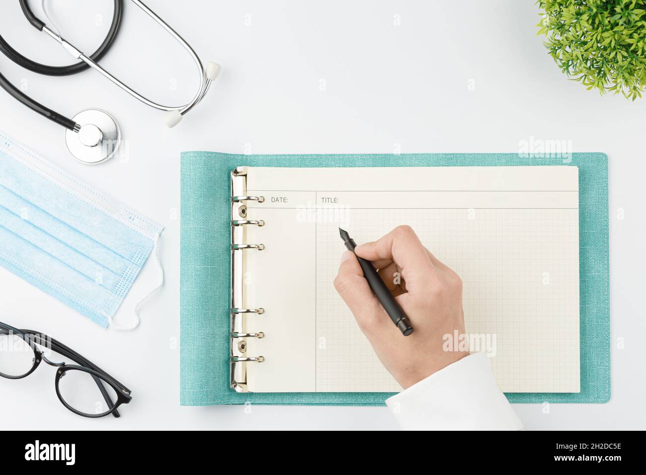 Medical worker at table write in notebook top view Stock Photo - Alamy