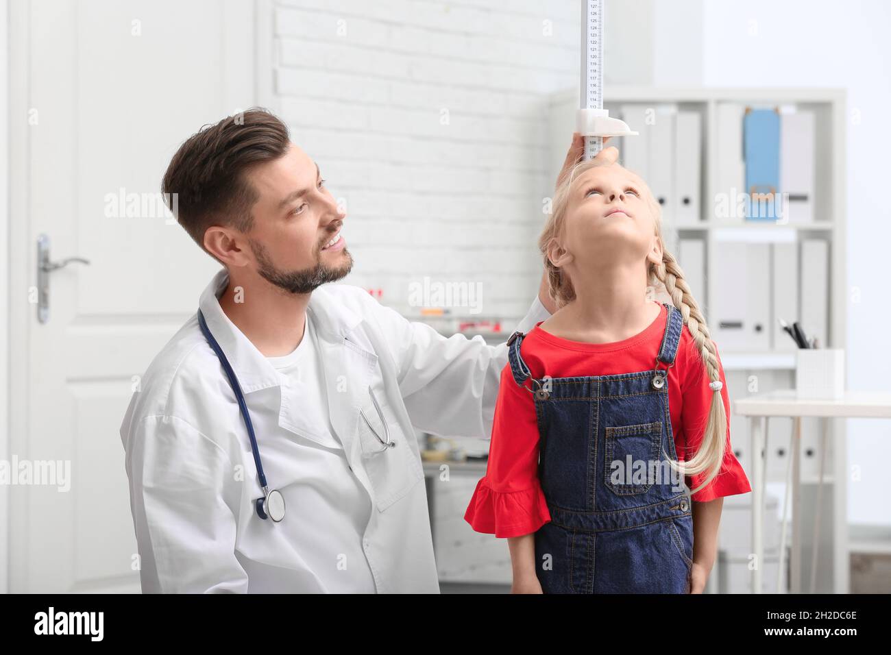 Doctor measuring little girl's height in hospital Stock Photo - Alamy