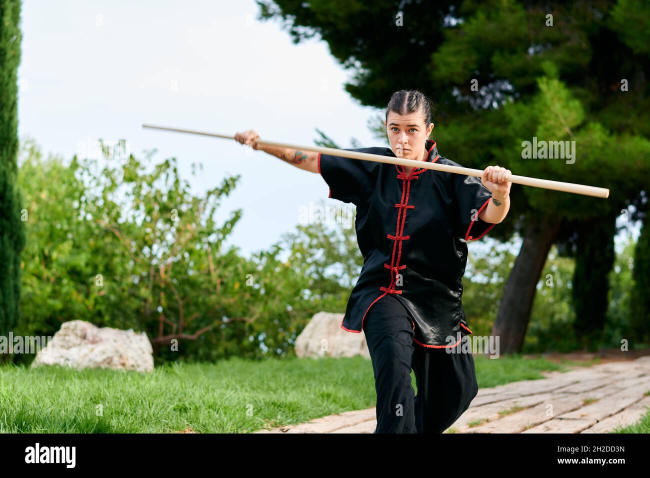 Woman in uniform practicing martial arts with a stick Stock Photo - Alamy