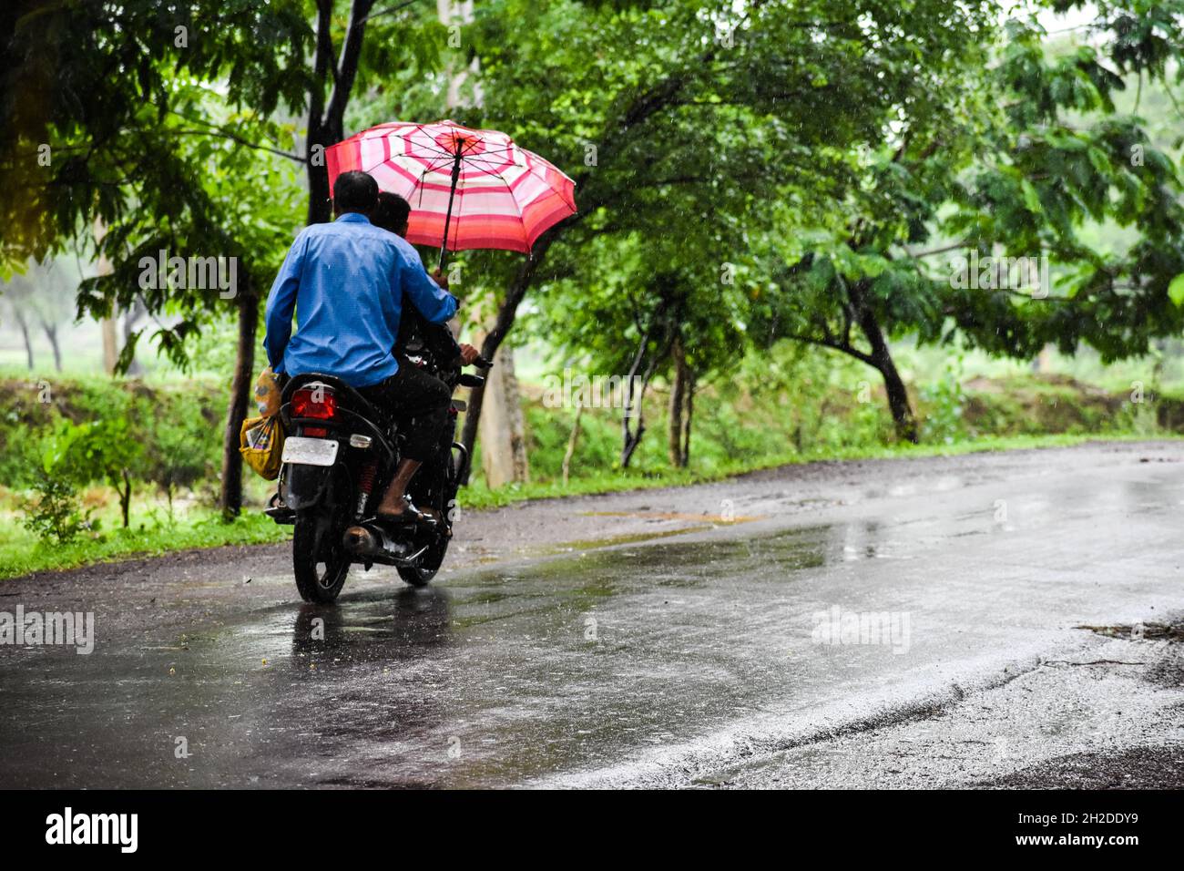People riding a motorcycle on a rainy day Stock Photo - Alamy